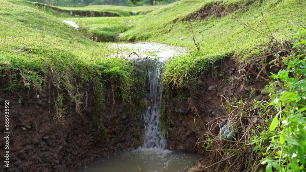 Stockvideon Water flowing in farm field waterway after heavy rain and ...