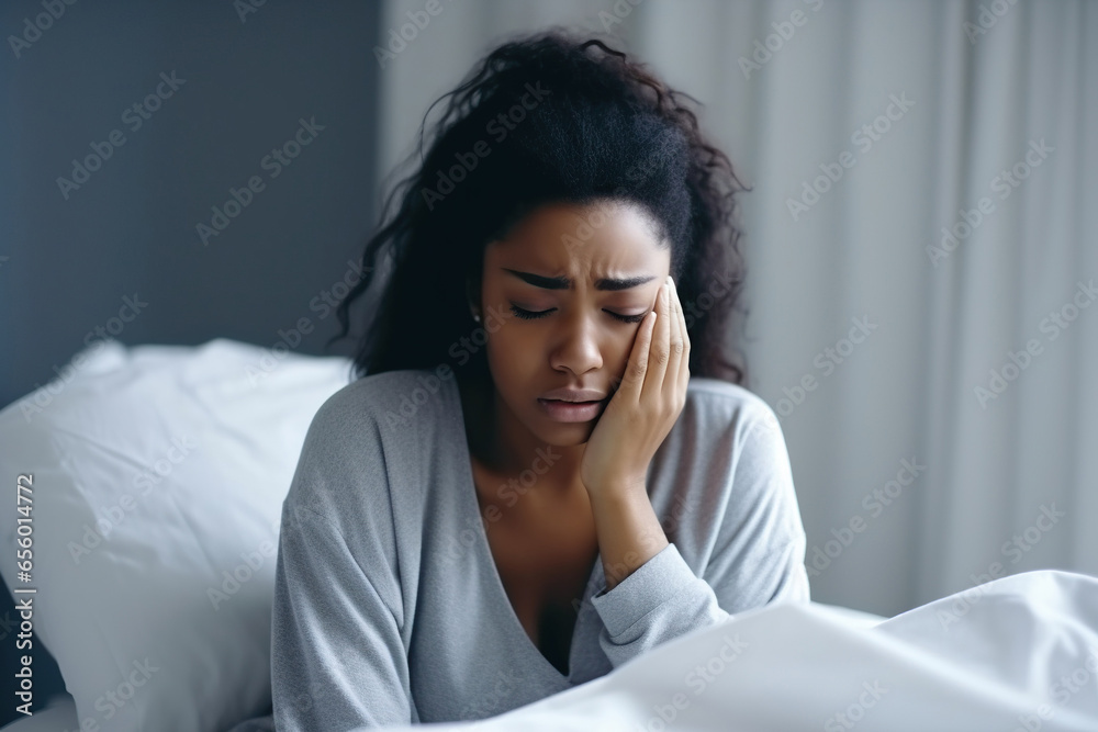 Sad African American female patient sitting on bed and crying in ...