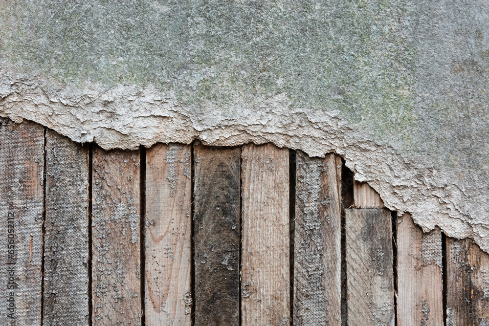 A fragment of an old wall panel made of wooden blocks and a torn ...