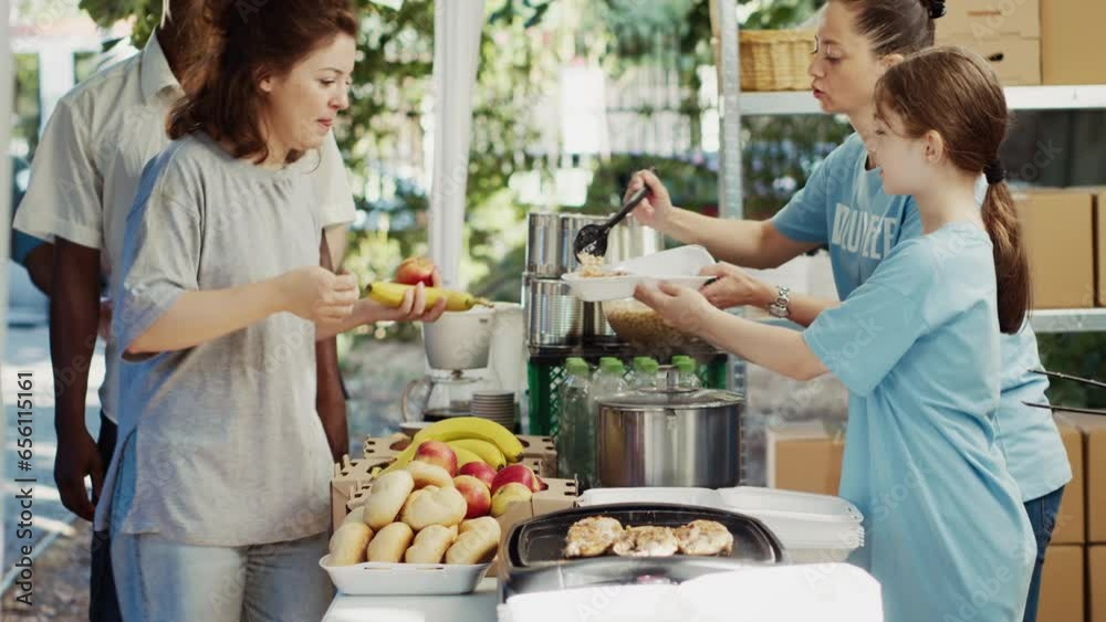 At non-profit food drive, side-view of female charity workers handing ...