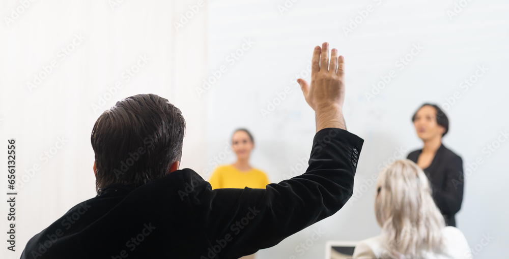 Businessman rises hand up for the question in the diverse employees ...