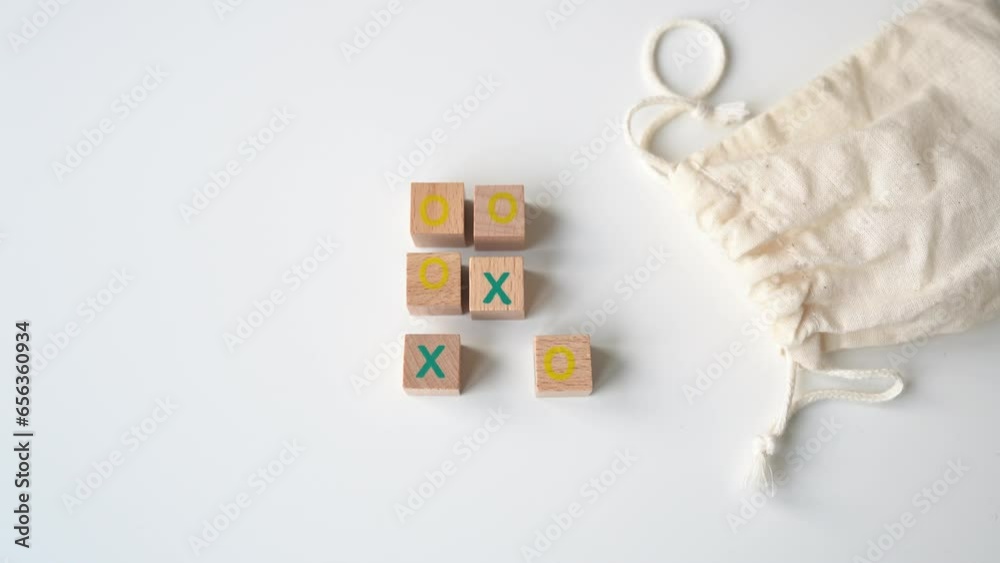 Wooden dice game TIC-TAC-TOE on a grey background with white bag with ...