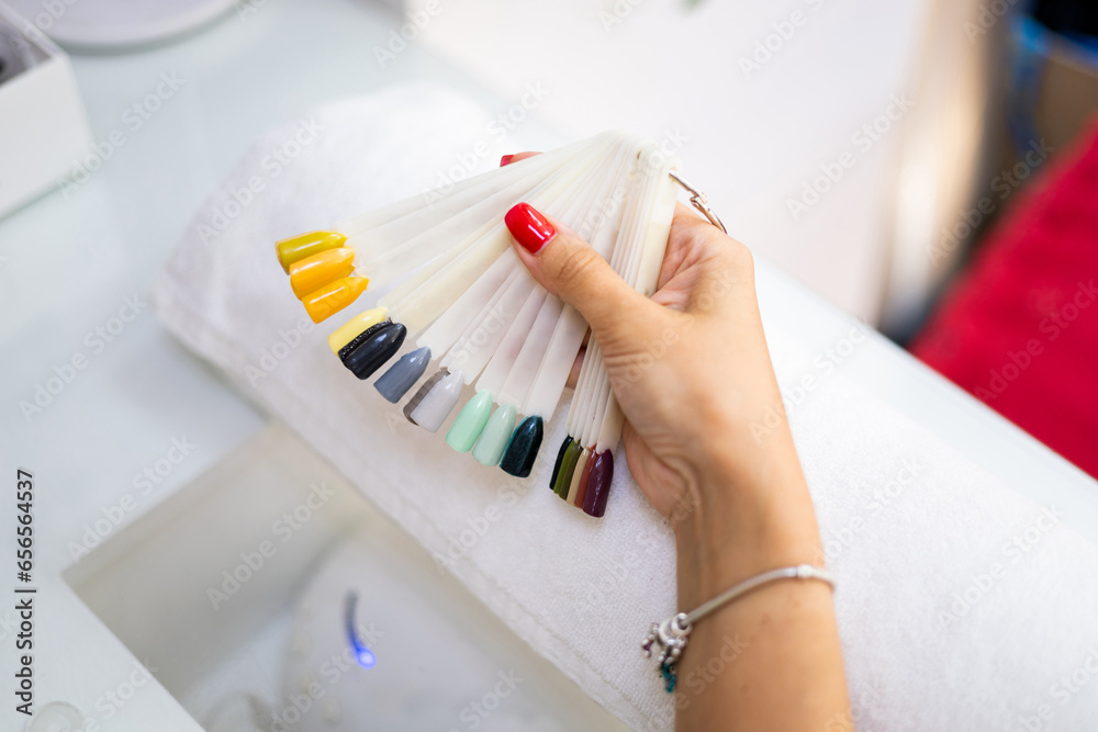 Detail of a hand of an unrecognizable woman chooses the color of the ...