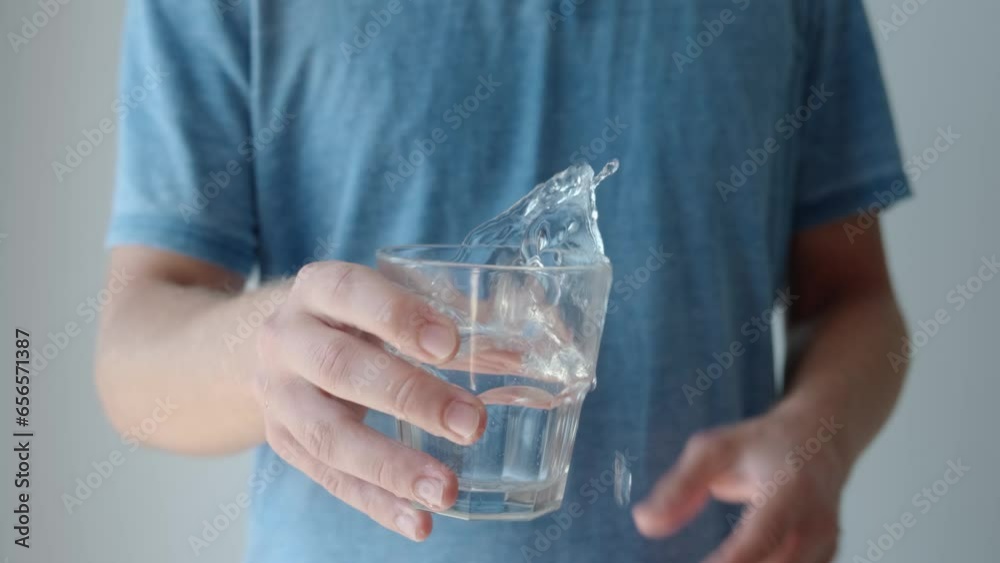 Man holding drinking glass with shaking hands suffering from tremor ...