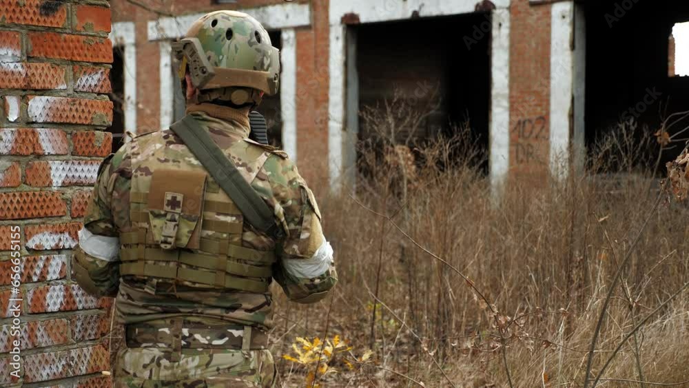 Two men in military camouflage uniforms with automatic rifles with ...
