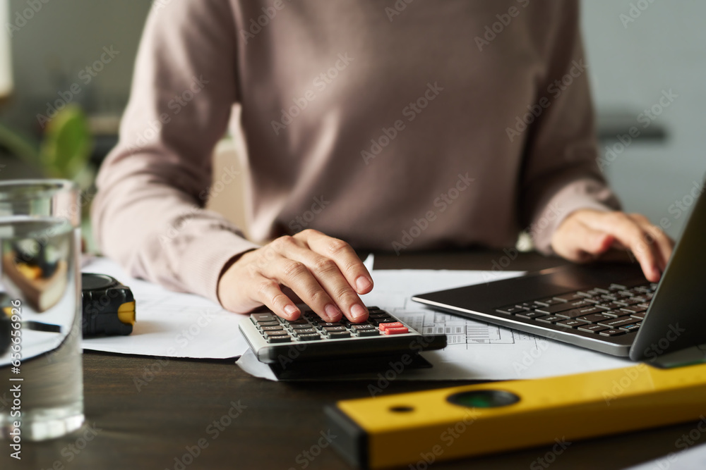 Focus on hand of young female architect and accountant using calculator ...