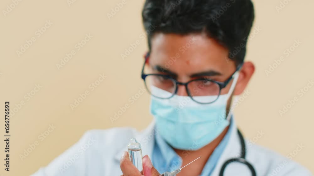 Indian young doctor cardiologist man holds syringe needle and ampoule ...