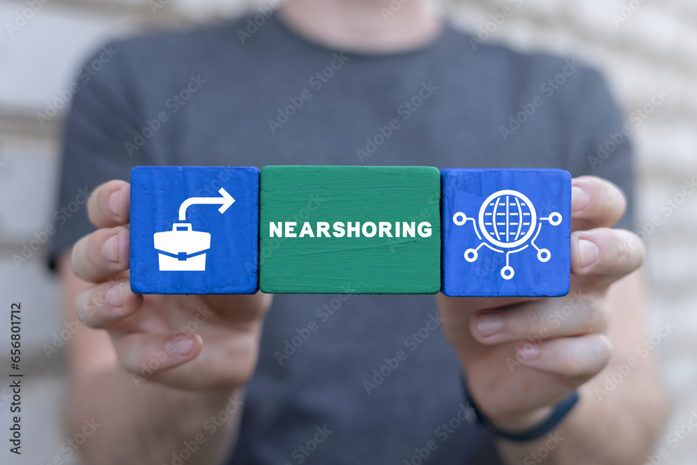 Man holding colorful blocks with icons sees word: NEARSHORING. Business ...