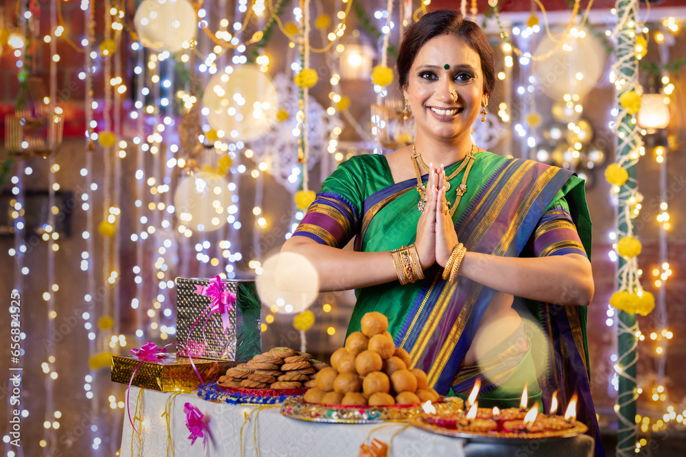 Beautiful Indian woman in sari greeting with namaste gesture at diwali ...