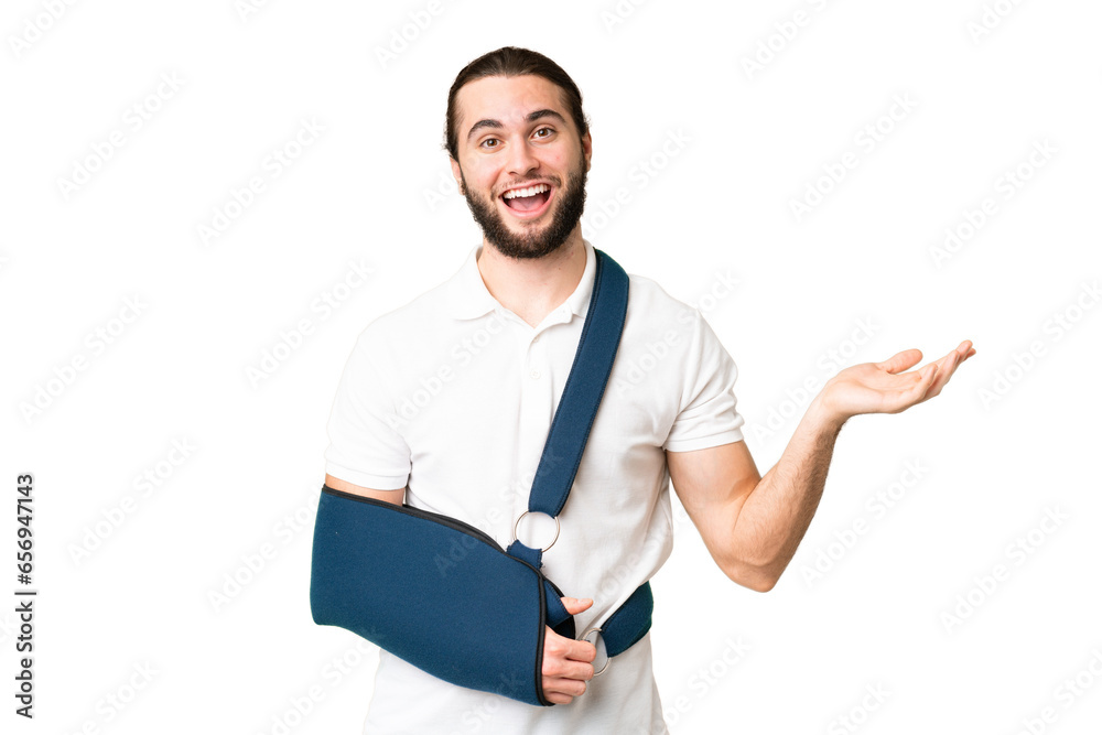 Young handsome man with broken arm and wearing a sling over isolated ...