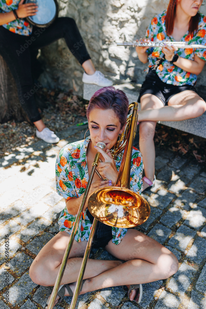 Woman playing trombone sitting cross-legged on floor Stock Photo ...