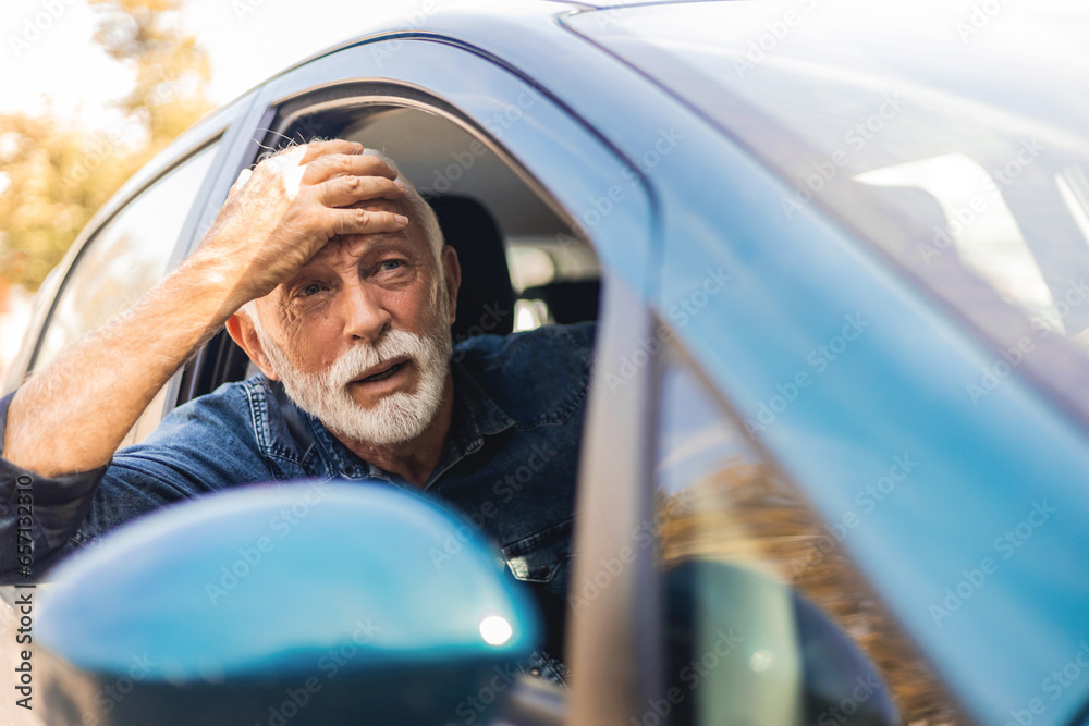 Angry man driving a car. The old men with an expression of displeasure ...