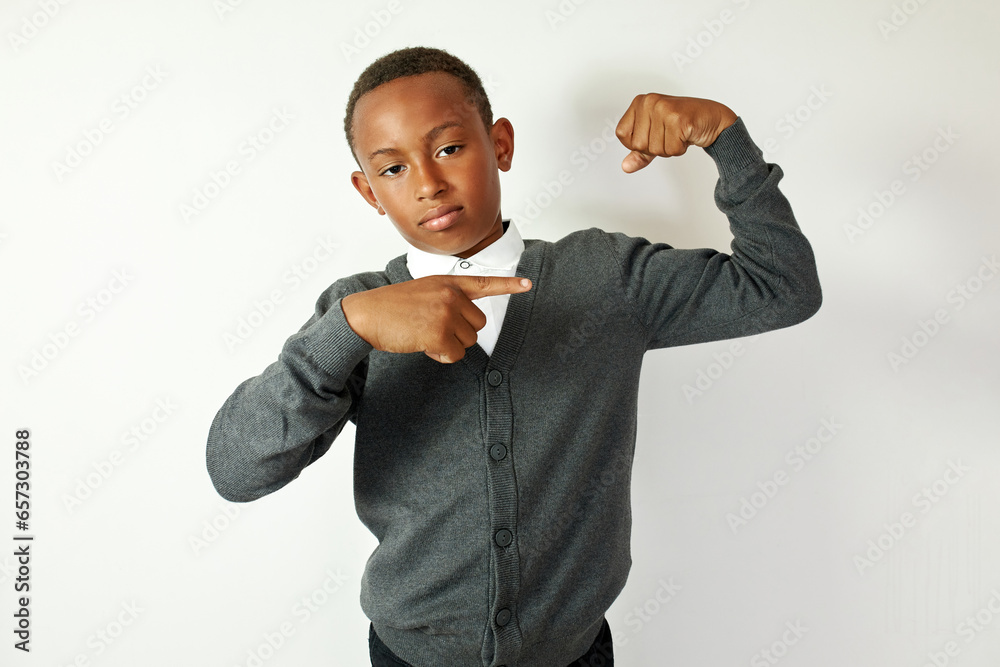 Black school kid in gray cardigan of 12 showing his bicep, feeling ...