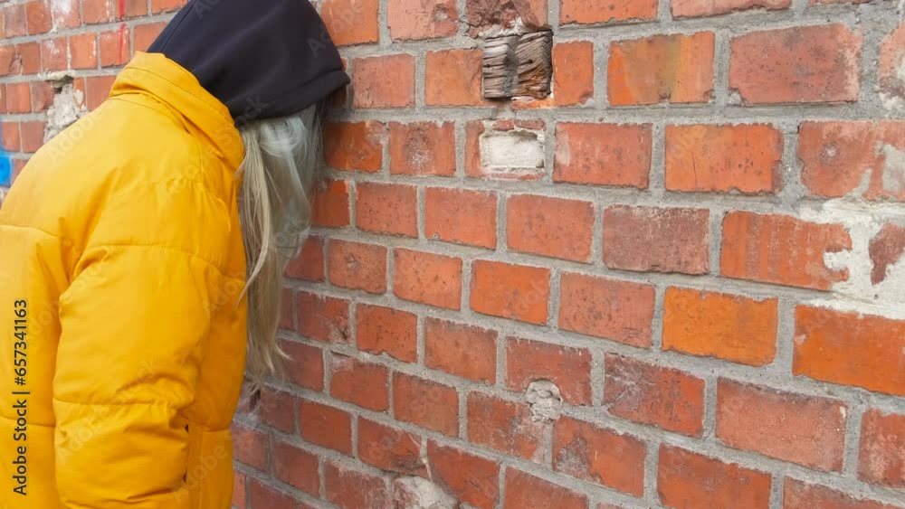 Crying teen by a brick wall. A view of crying girl with blue hair stand ...