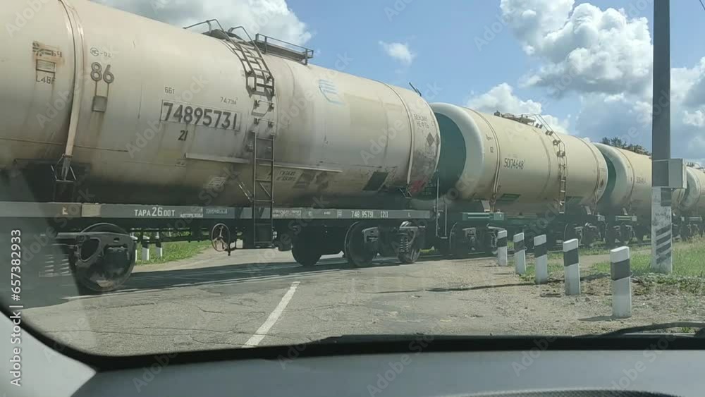 A freight train with liquid tanks and freight cars passes a railway ...