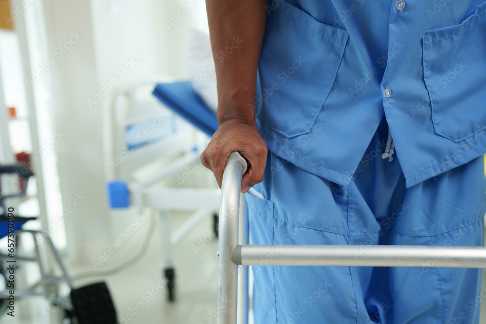 Physical therapist helps a male patient use a walker to practice ...