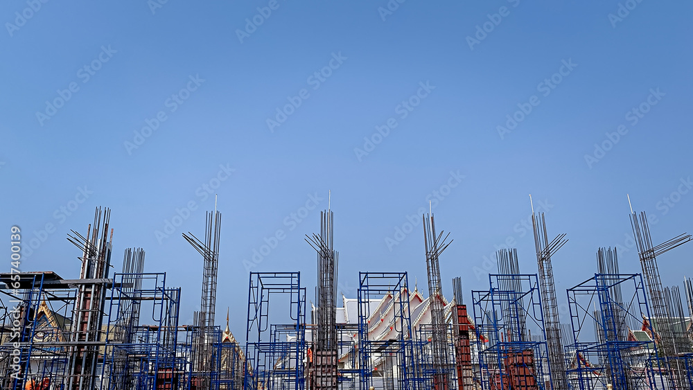 Steel frame of a high-rise building under construction against blue sky ...