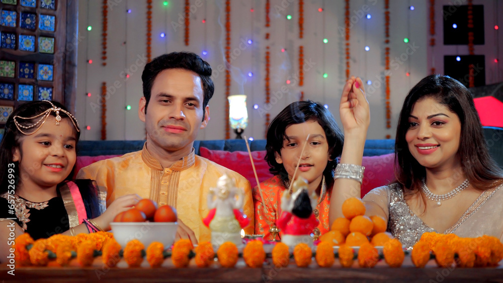 An Indian family happily showering flower petals while doing Diwali ...