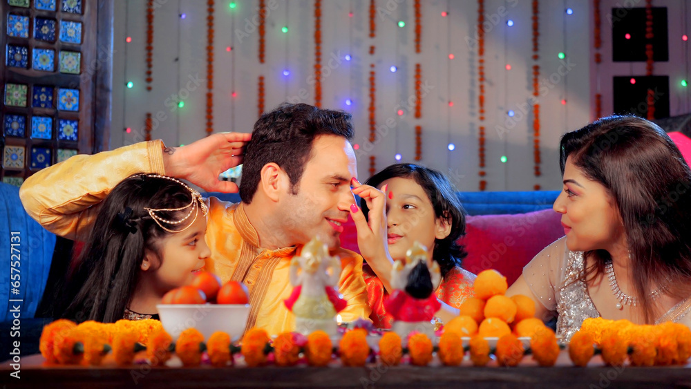 An Indian woman putting a red Tika for all the family members after ...