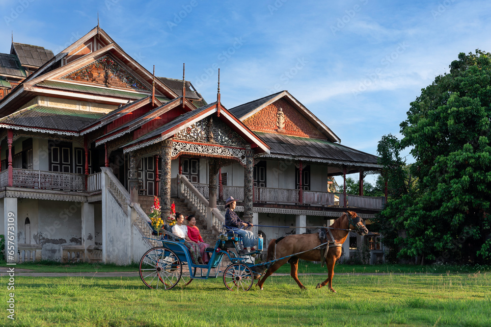 Women dressed in Burmese clothing and horse-drawn carriage at an ...