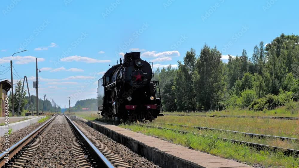 Vidéo Stock Steam locomotive drives on the railway passing the camera ...