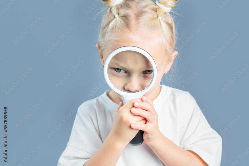 Girl looking through magnifying glass, glass to magnify objects ...
