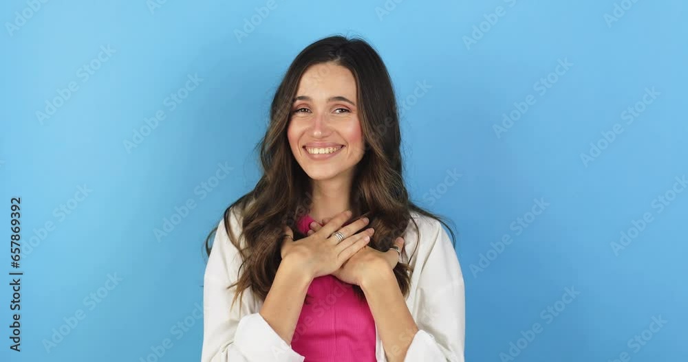 Impressed friendly pleasant looking woman keeps hands on chest, touched ...