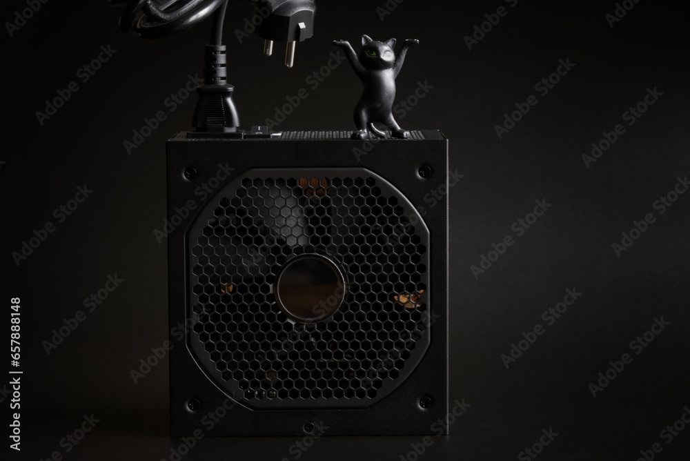 Black computer AC power supply unit with a powerful fan on a black ...