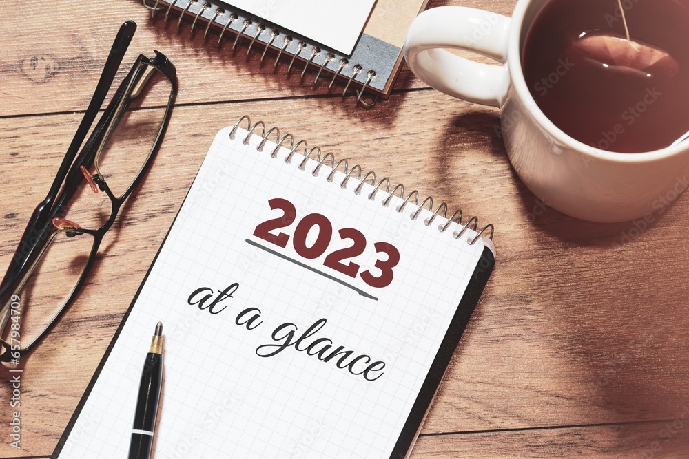 2023 at a glance text on notepad on wooden desk. 2023 Year in review ...