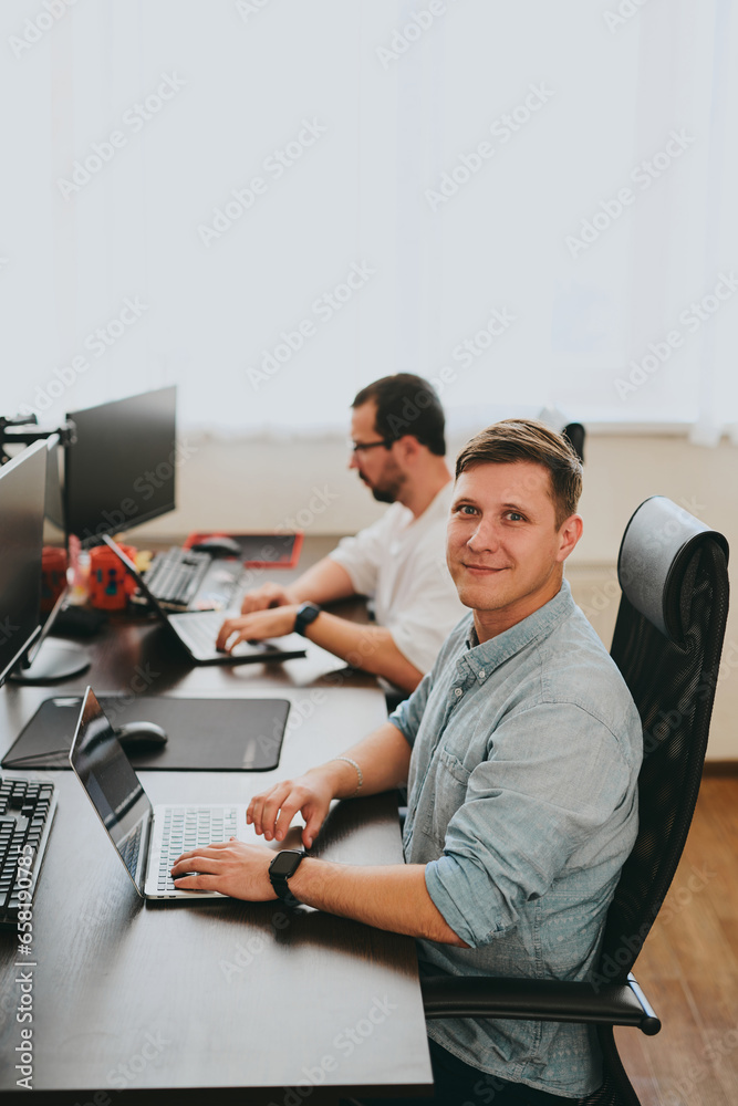 Portrait of two professional male programmers working on computer in ...