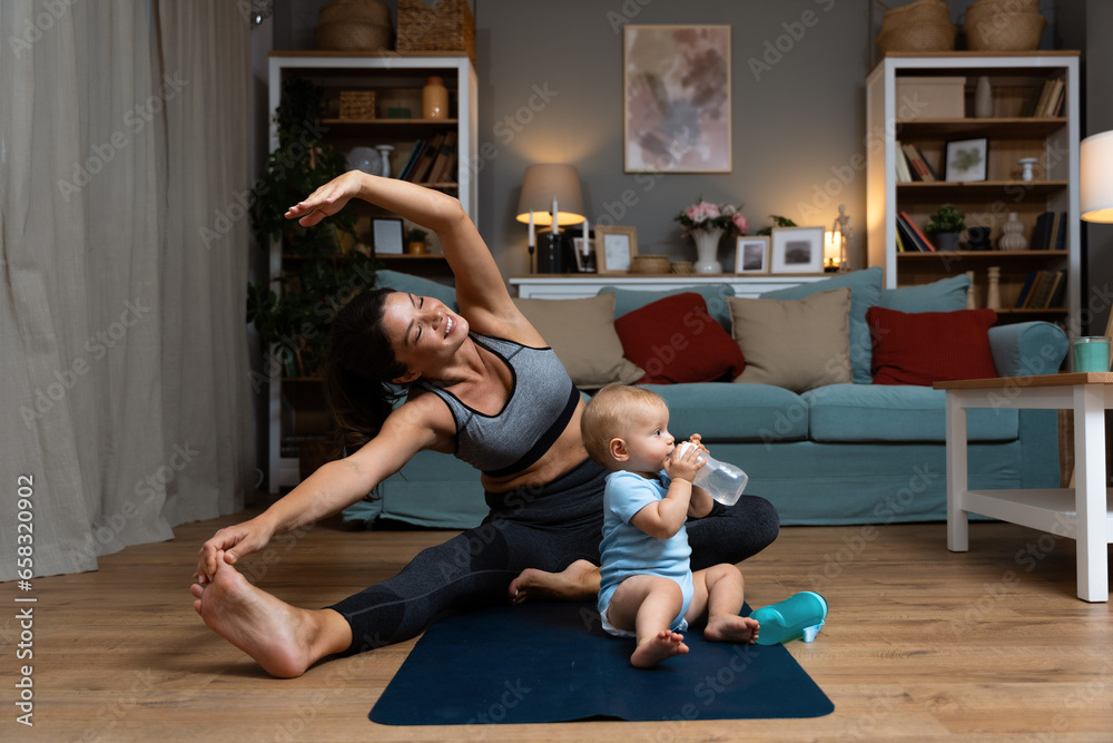 Young happy successful independent single mother is practicing yoga at ...