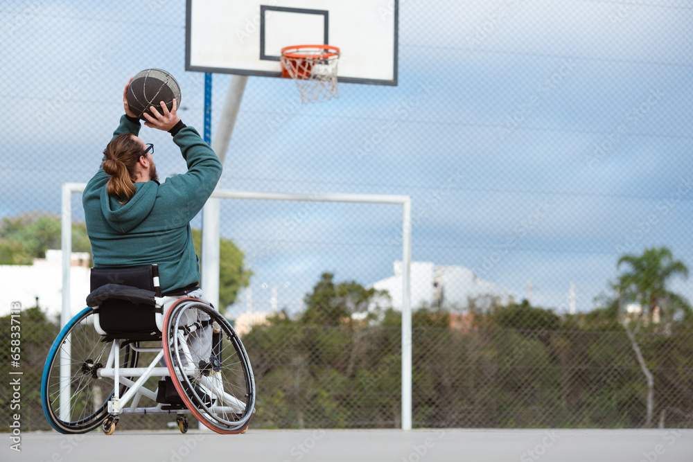 player in wheelchair throwing ball to practice shot in open basketball ...