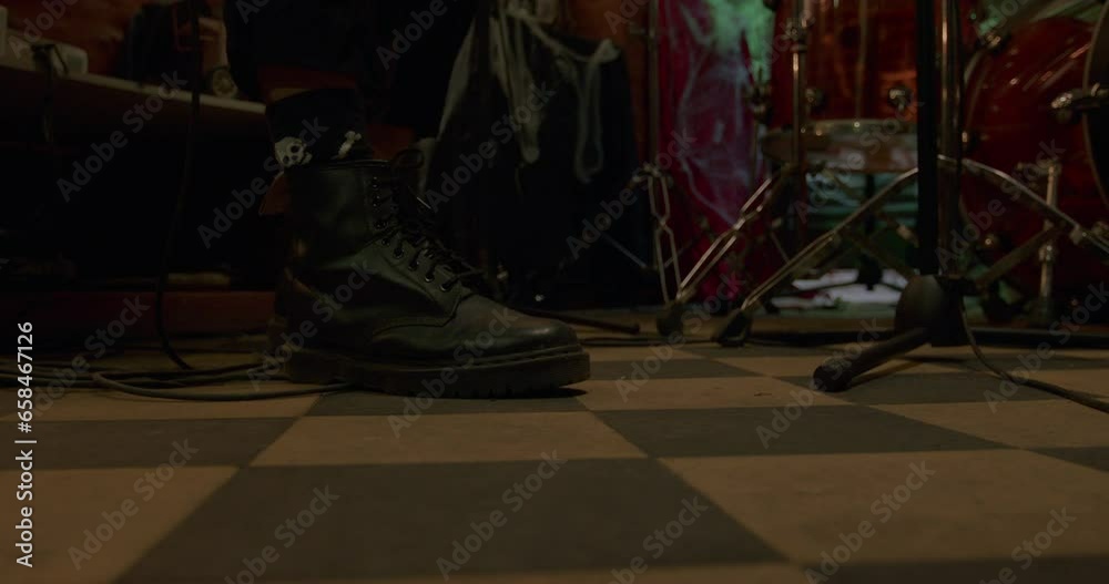 Musician in boots with socks with a skeleton, a skull, feet stomping on ...