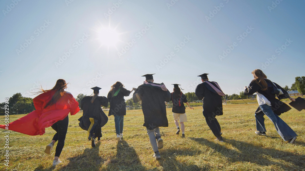 Happy graduates run in and take off their robes. The concept of ...