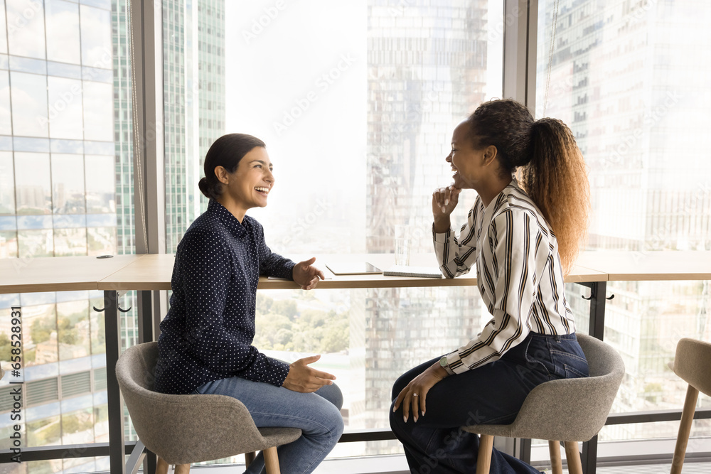 Cheerful happy young diverse office friends girls chatting on work ...