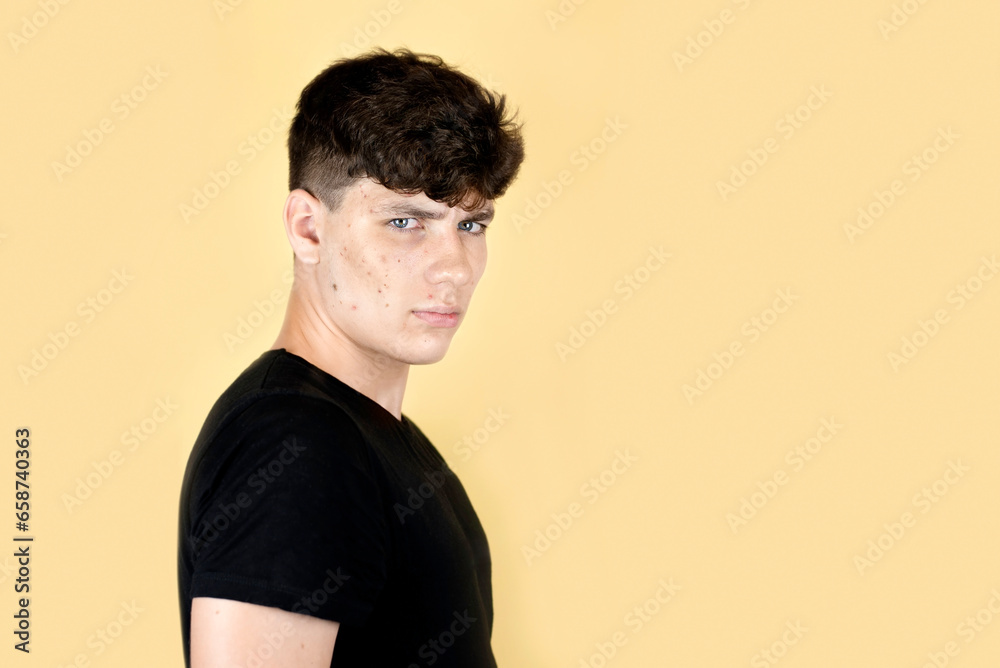 A teenage boy on a yellow background is sad because he has problems ...