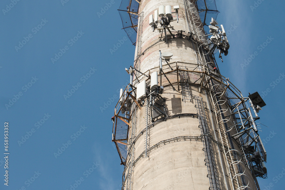 High concrete chimney. Communication antennas on chimney. Industrial ...