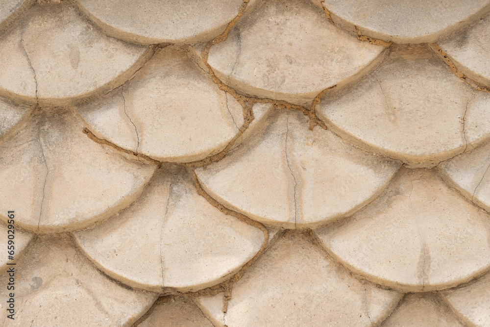 Close-up shot of a wall designed to resemble fish scales. Concrete ...