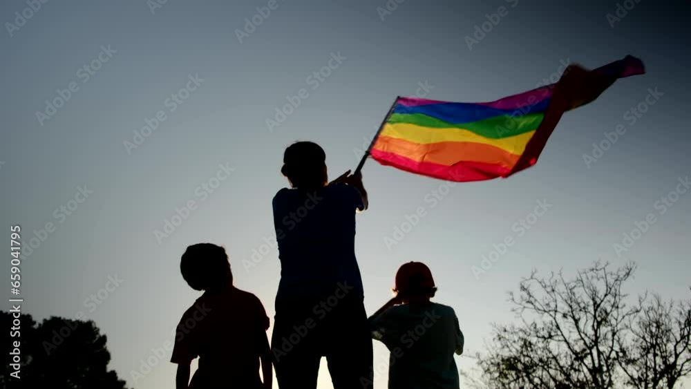 A silhouette of an LGBTQ+ mother and her children proudly waving the ...