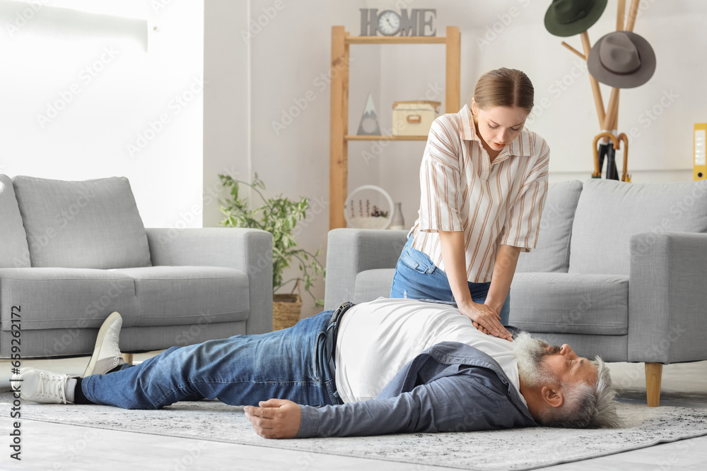 Woman doing CPR on her unconscious father at home Stock Photo | Adobe Stock