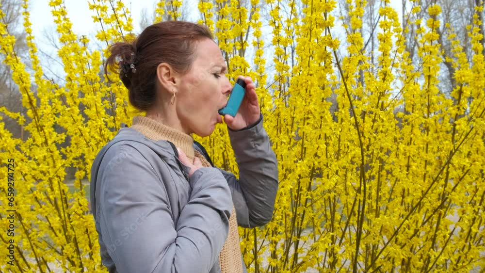 Allergic female with inhaler in park. A view of allergic woman suffer ...