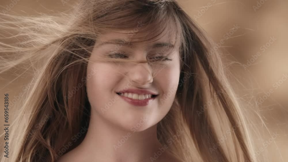 Close-up shot of a young woman with long white hair. She is twisting ...