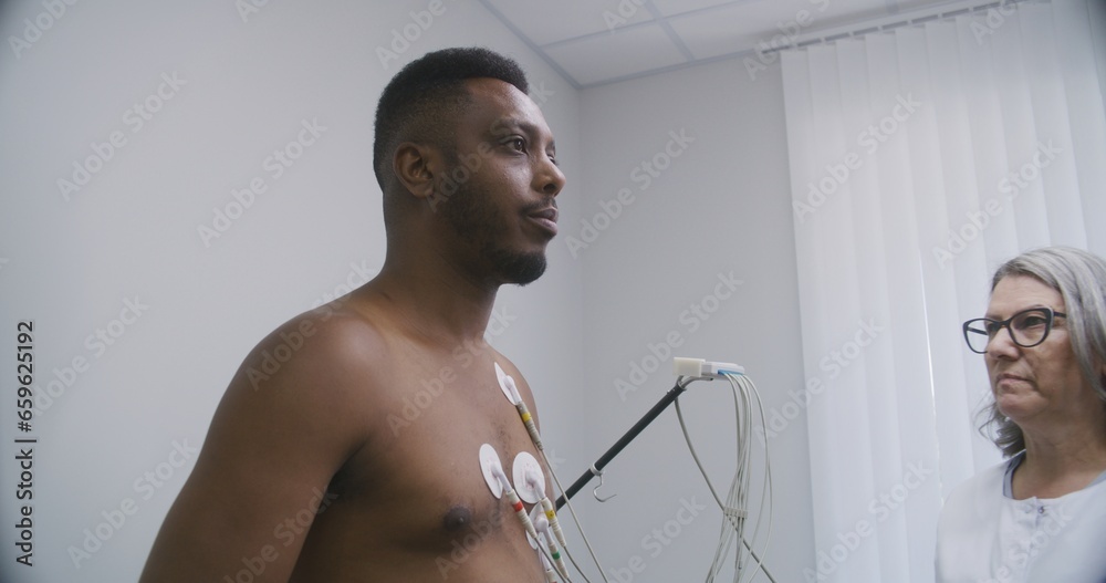 Female cardiologist, doctor puts holter sensors on patient with ... Female cardiologist, doctor puts holter sensors on patient with ...