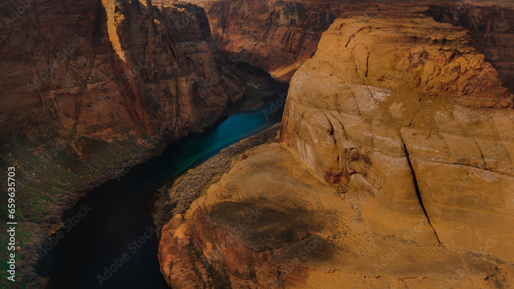 Cloud shadows drift across the sun baked vertical sandstone cliffs that ...