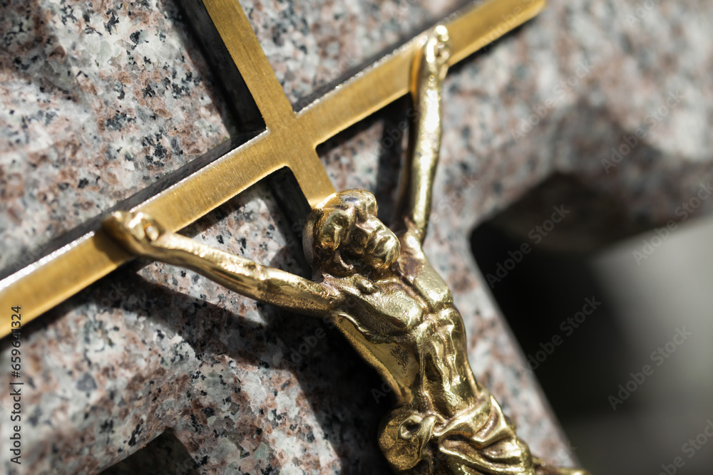 Jesus crucified golden metal statue. Weathered granite cross. Graveyard ...