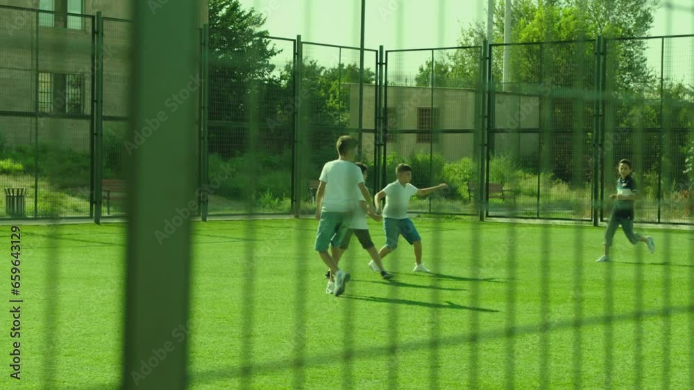 Group of boys playing football on sport playground in sunny day . Many ...