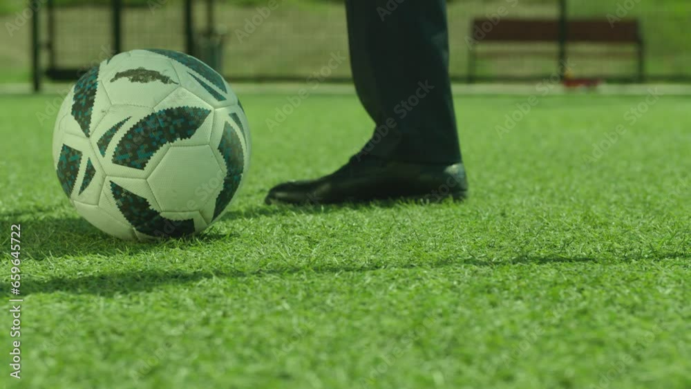 Disabled man with amputated leg kicking ball with crutch and scoring a ...