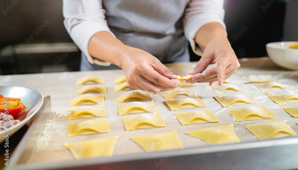 professional chef hands wrapping and filling preparing ravioli dough ...