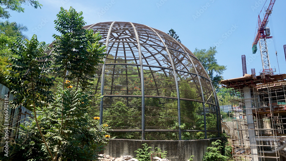 Large metal dome aviary for bird conservation next to a building ...