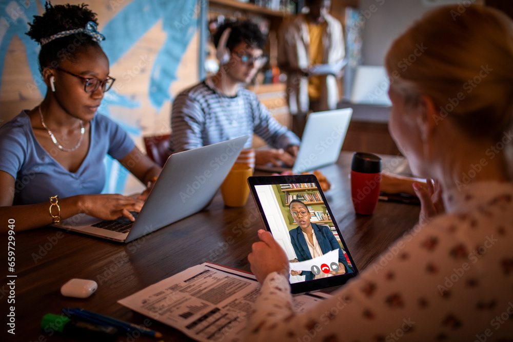 Young and diverse group of flat sharing roommates studying together and ...